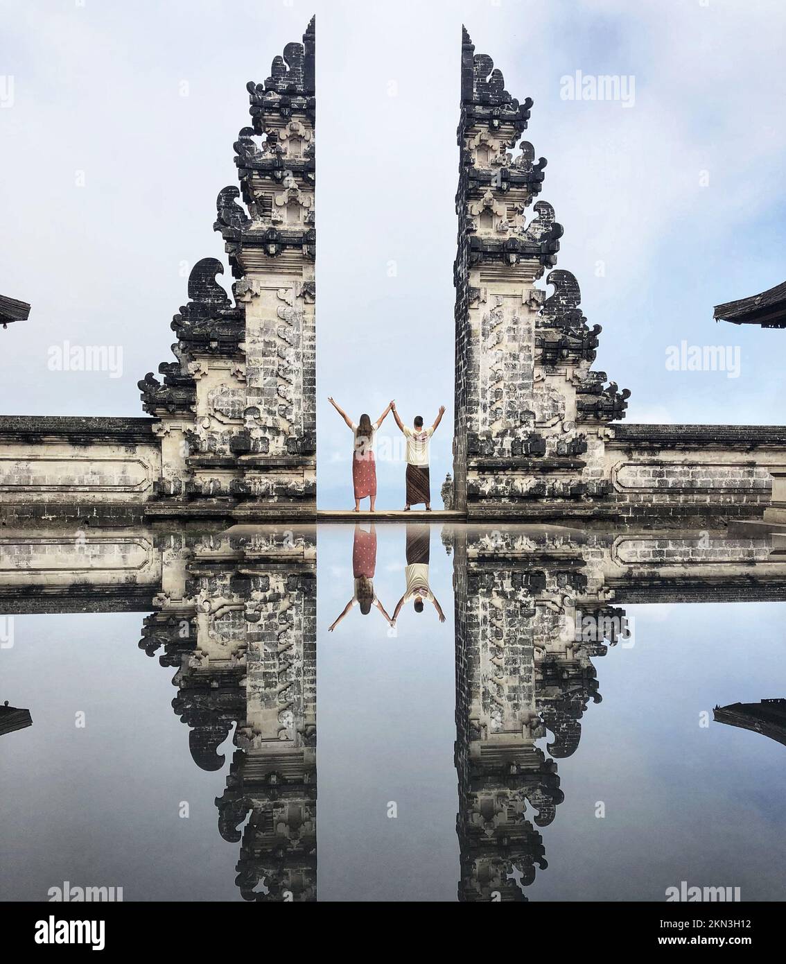 A vertical of a couple posing at Pura Penataran Agung Lempuyang ...