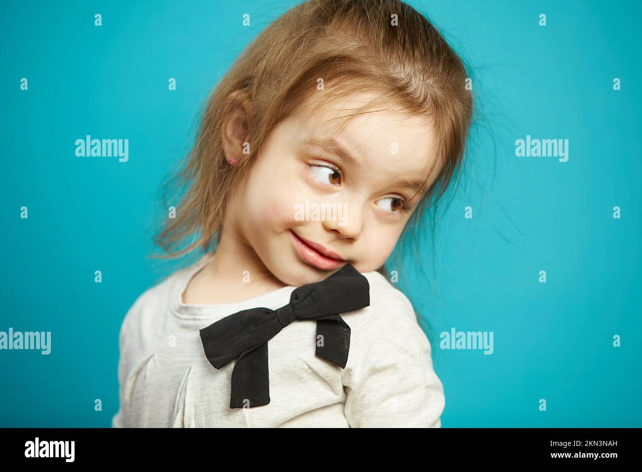 Little girl flirting and coquet, turns back, close-up portrait photo of ...