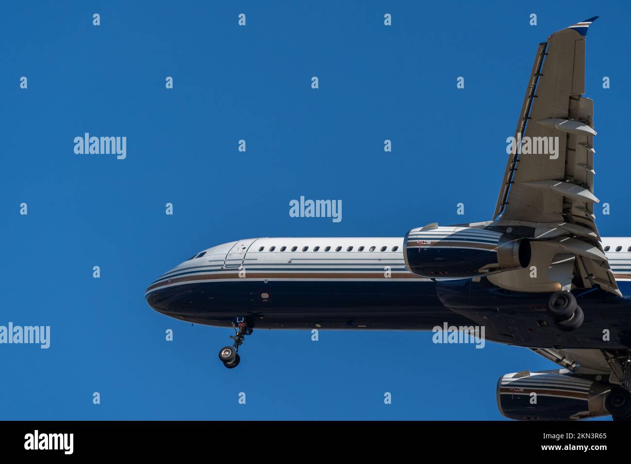 A large passenger plane crosses the blue sky, heading to the ...