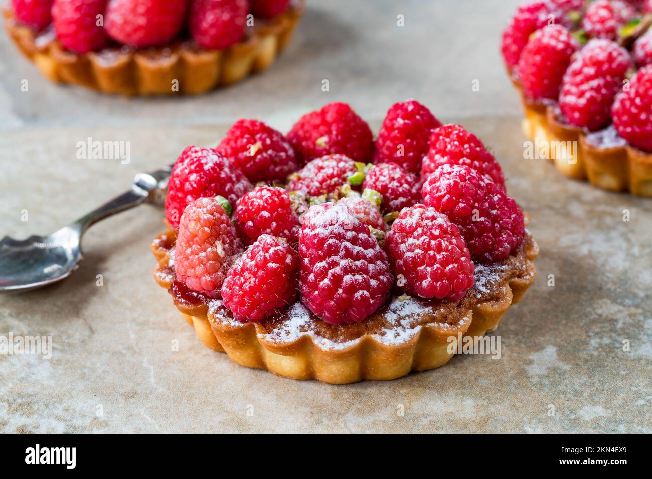Raspberry and pistachio tarts Stock Photo - Alamy