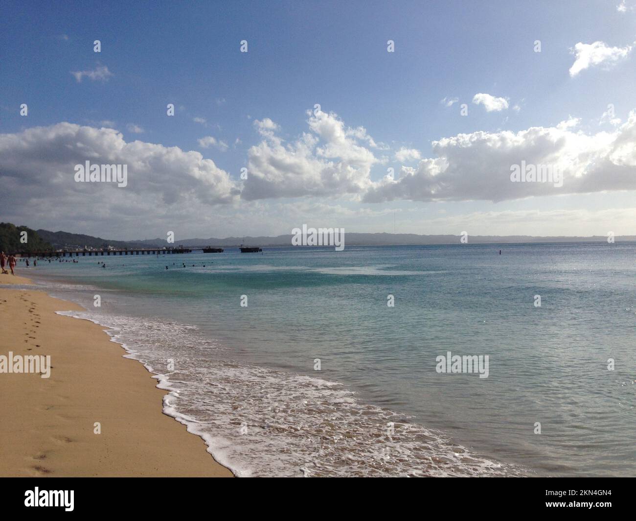 A beautiful shot of foamy waves crashing on a sandy beach in Puerto ...