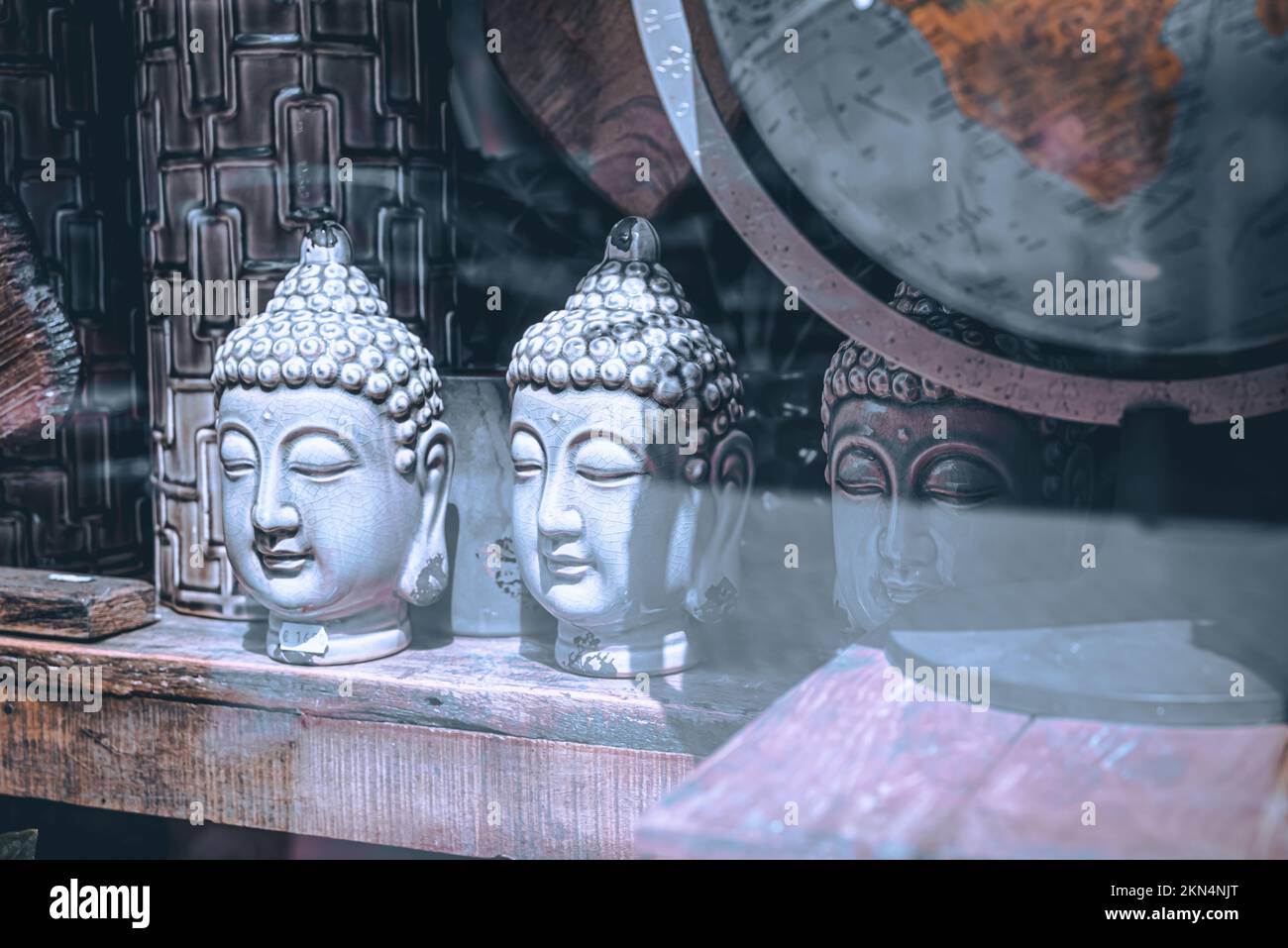 A display of the Buddha statue behind a shop window Stock Photo - Alamy