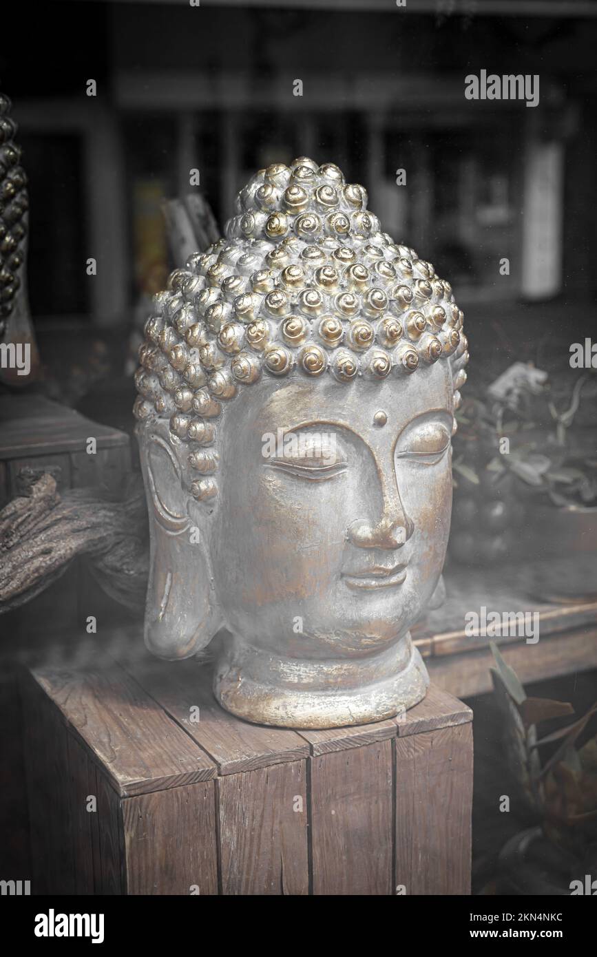 A display of the Buddha statue behind a shop window Stock Photo - Alamy