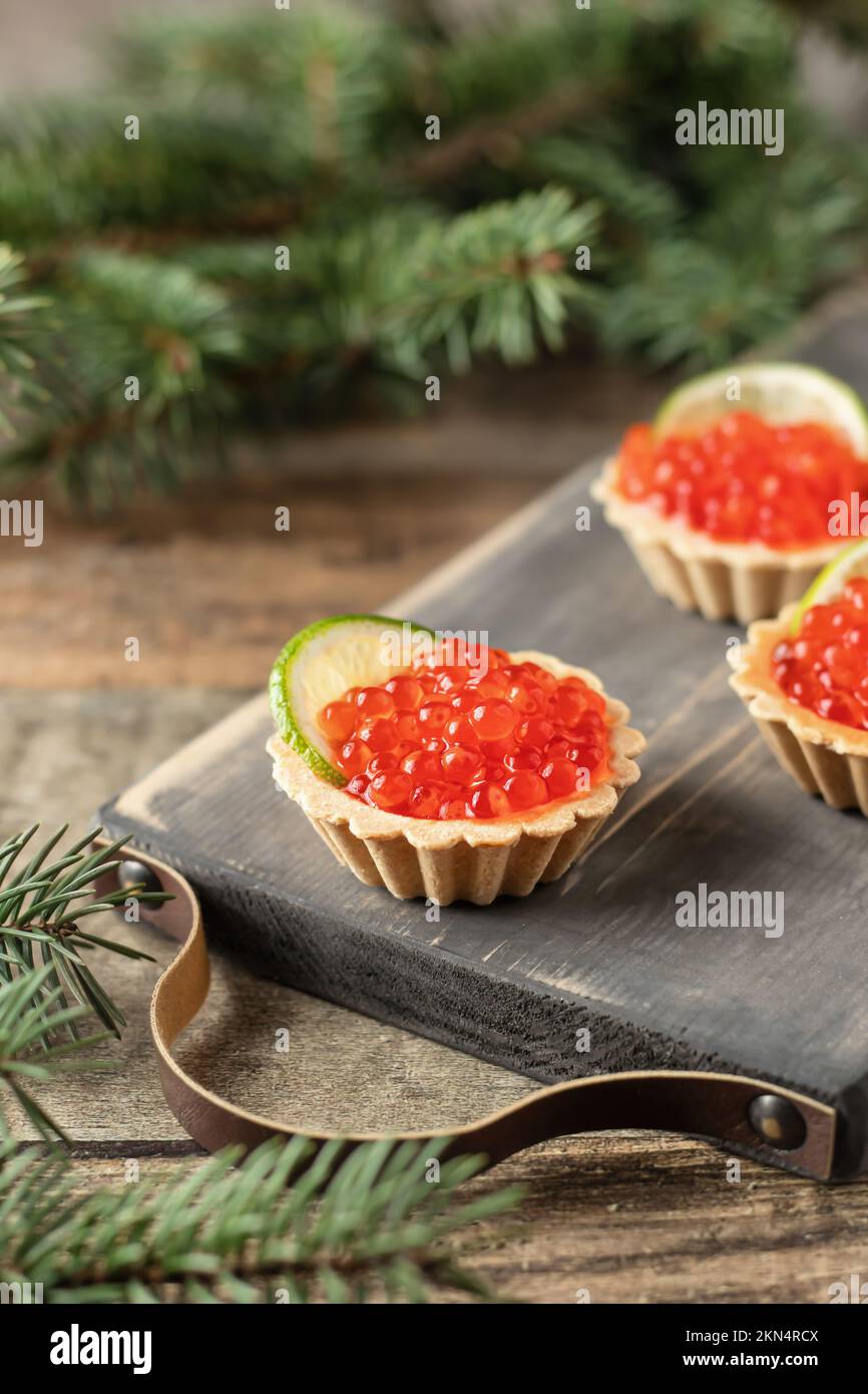 Festive New Year appetizer tartlets stuffed with red caviar and a slice ...