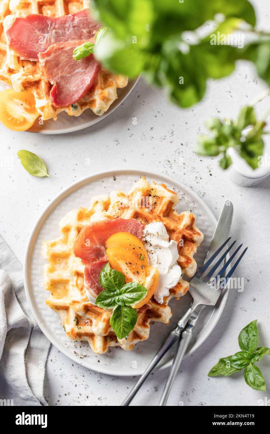Cheese or potato savory waffles served with with tomatoes, cream cheese ...