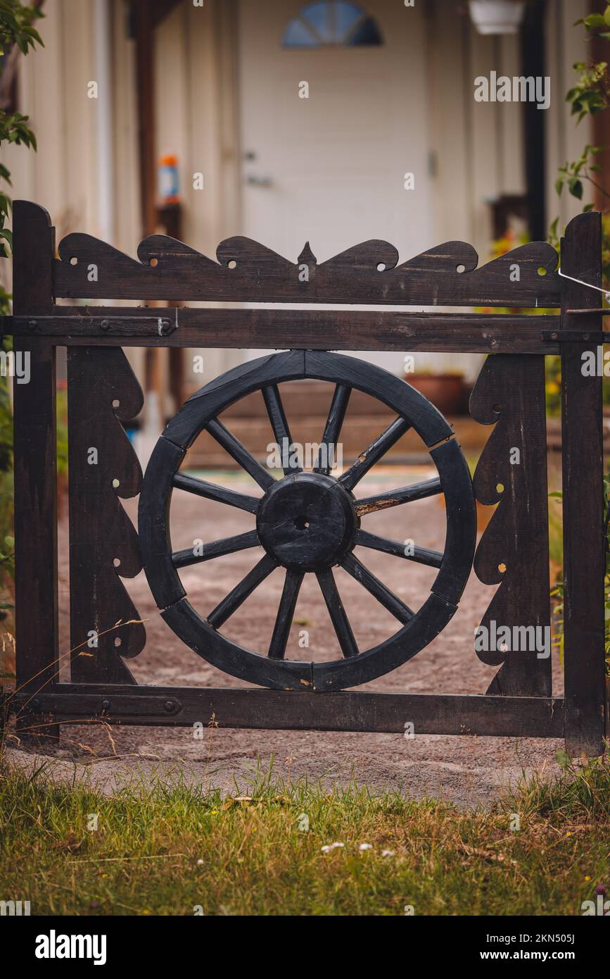 A vertical shot of an old wooden wheel-shaped fence in the countryside ...
