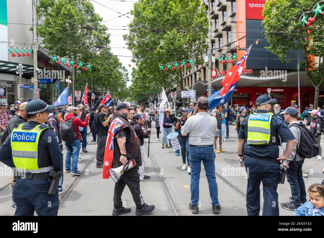Victorian pOlice officers monitor protestors in Melbourne city centre ...