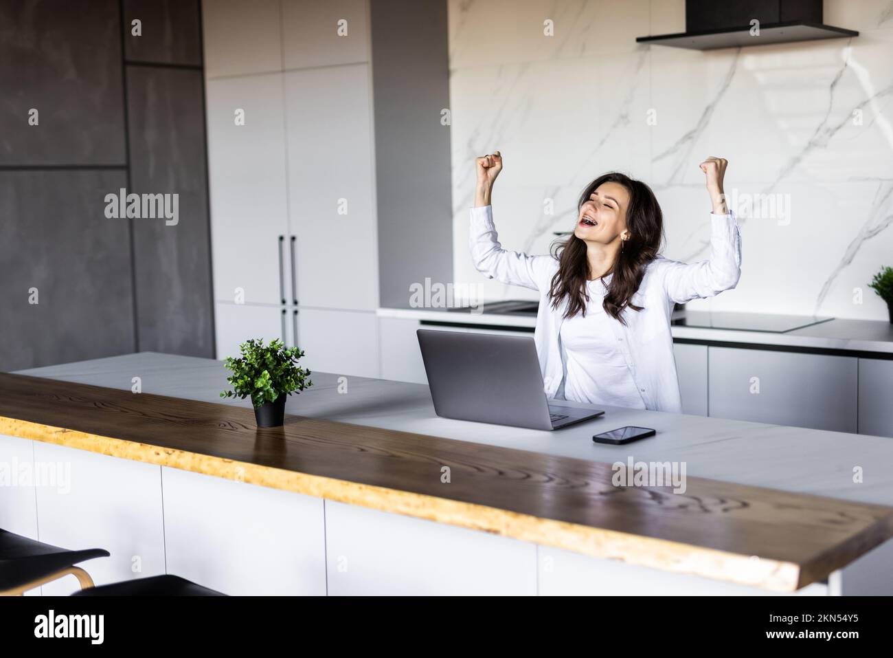 Happy laptop user woman celebrating good news, success, luck with winner yes hands, shouting for ...