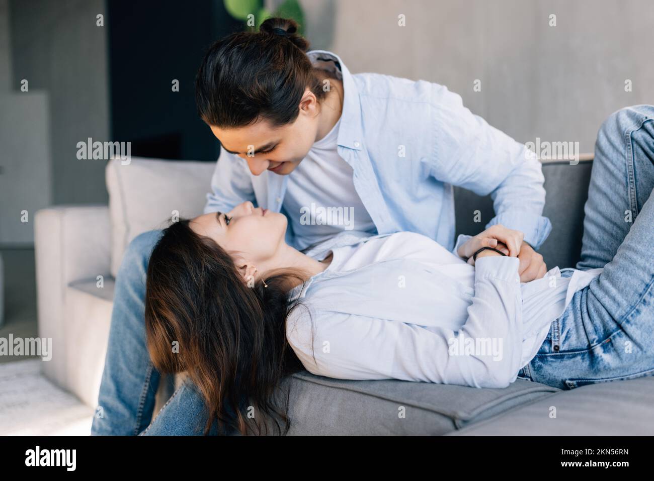 Loving relaxed couple kissing in the living room at home Stock Photo ...