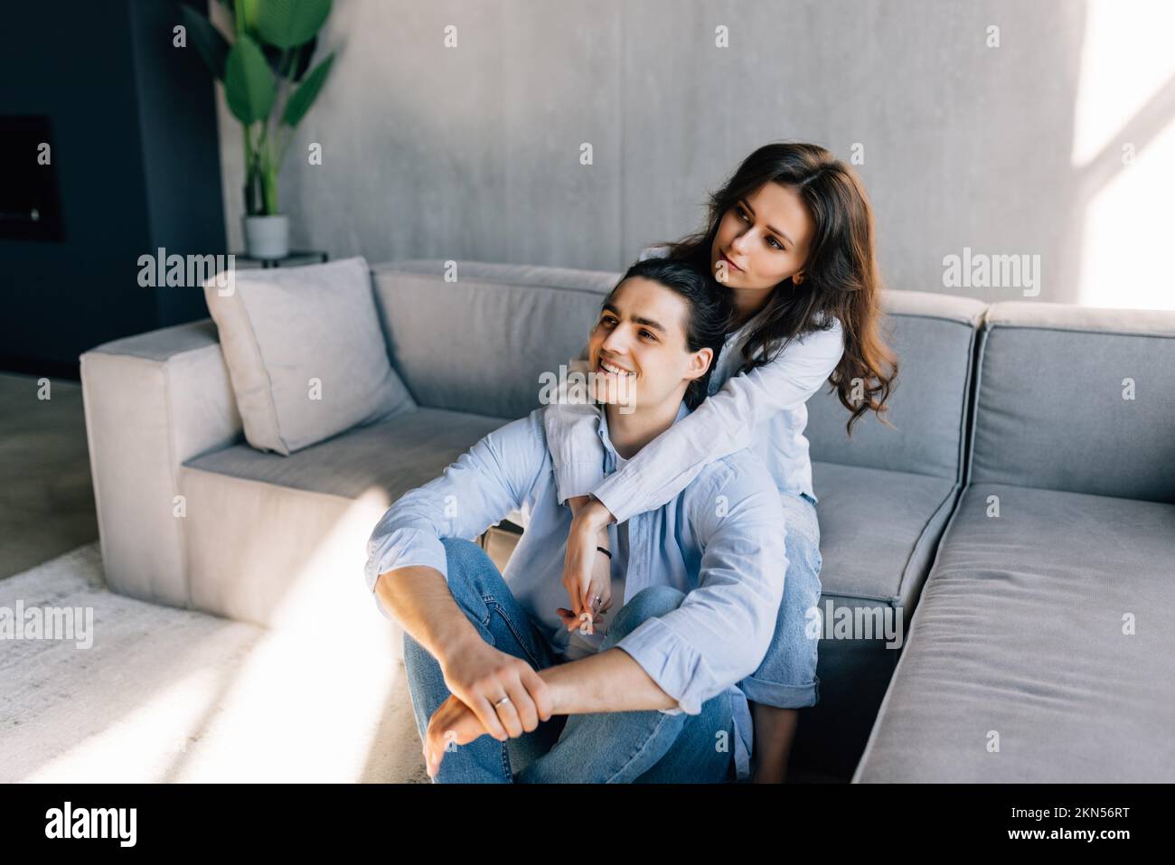 Portrait of young couple in love posing photo shooting seated on couch ...