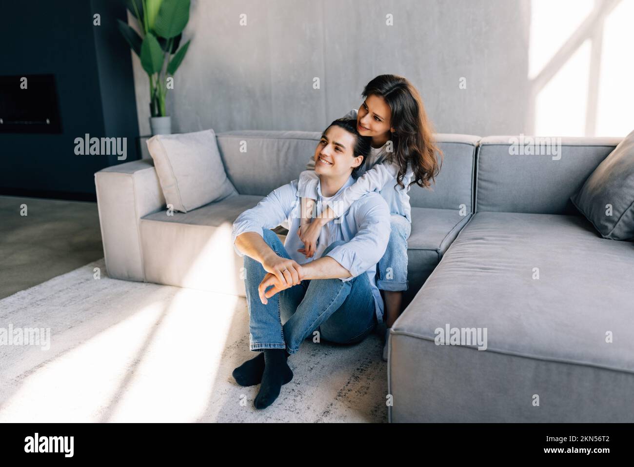 Portrait of young couple in love posing photo shooting seated on couch ...
