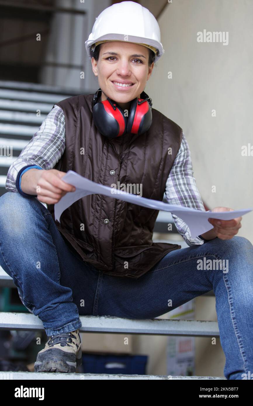 beautiful woman engineer is smiling and looking a blueprint plan Stock ...