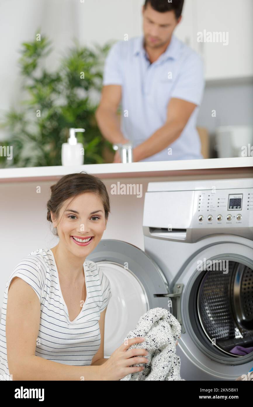 beautiful woman is smiling while doing laundry at home Stock Photo - Alamy