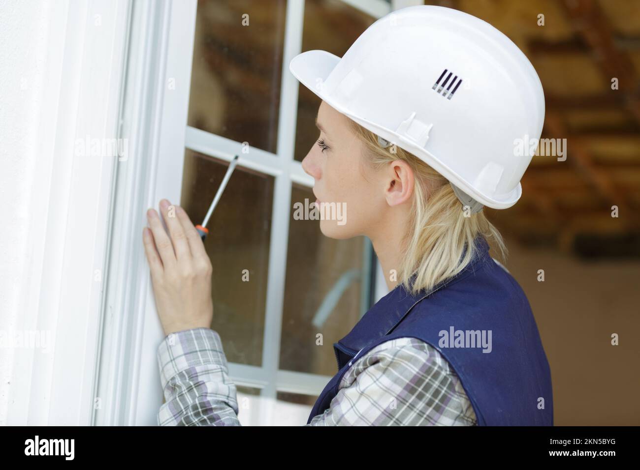 a woman installing a window Stock Photo - Alamy