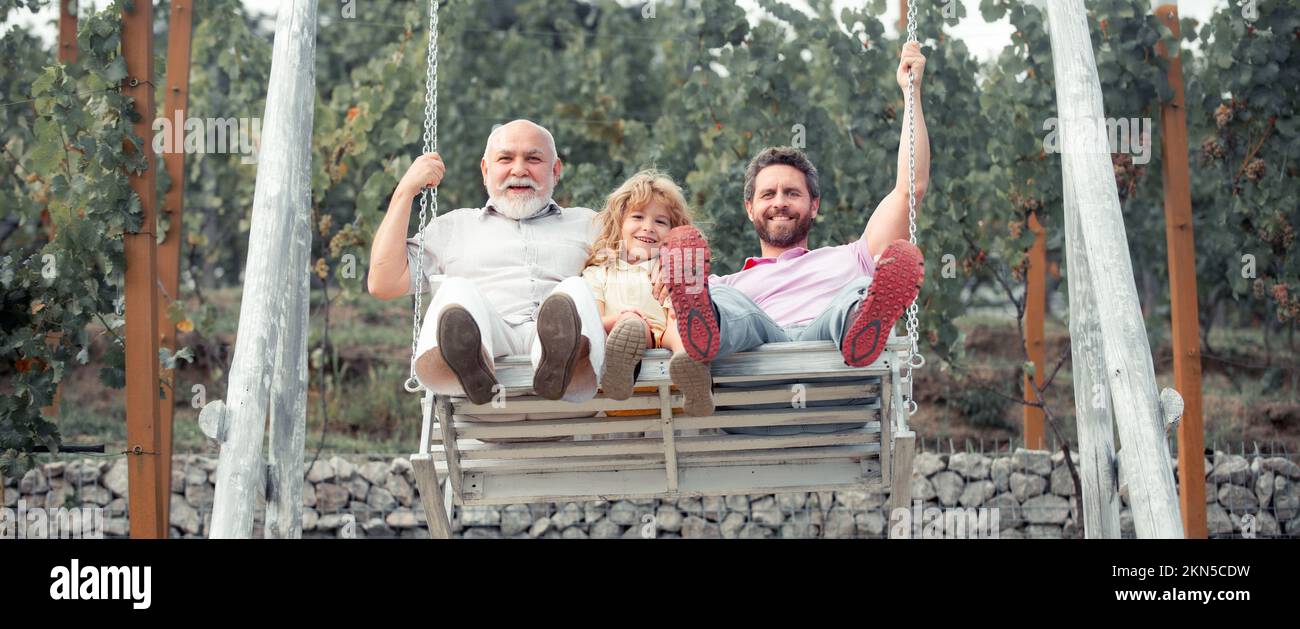Excited grandfather father and son playing outdoors, sitting on the ...