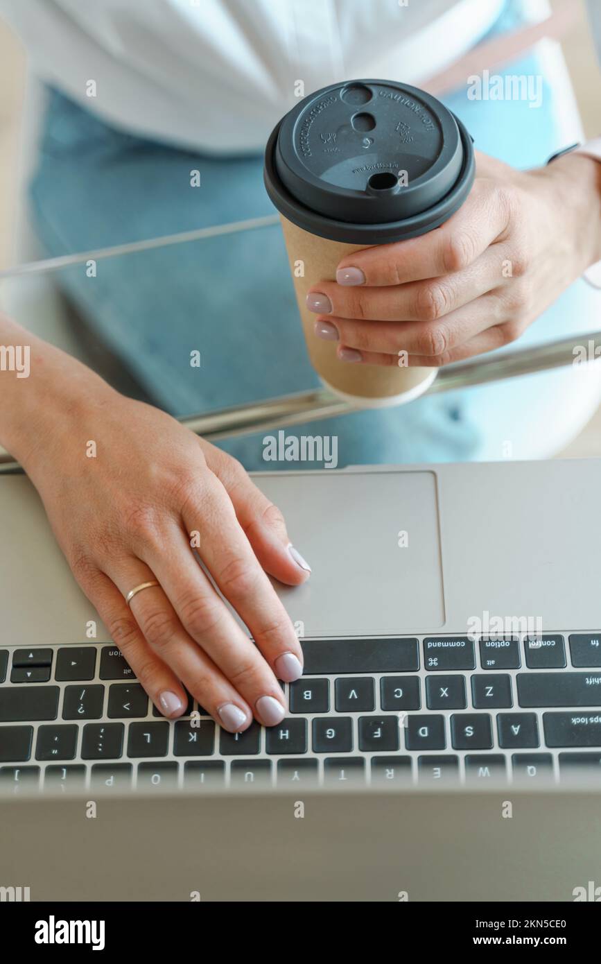 Hands typing on a computer keyboard over a white office table with a ...