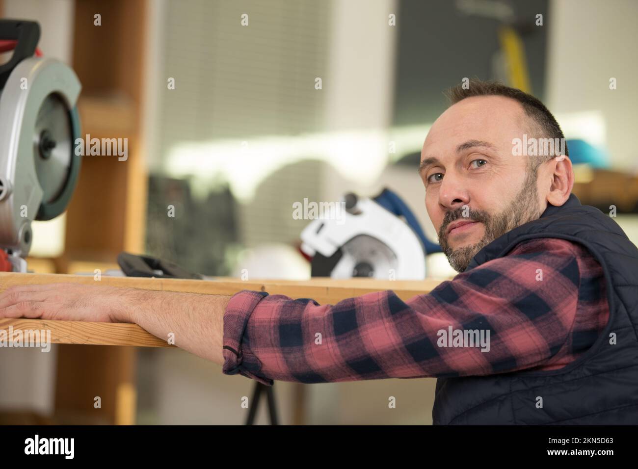 male construction carpenter saws a modern circular saw Stock Photo - Alamy