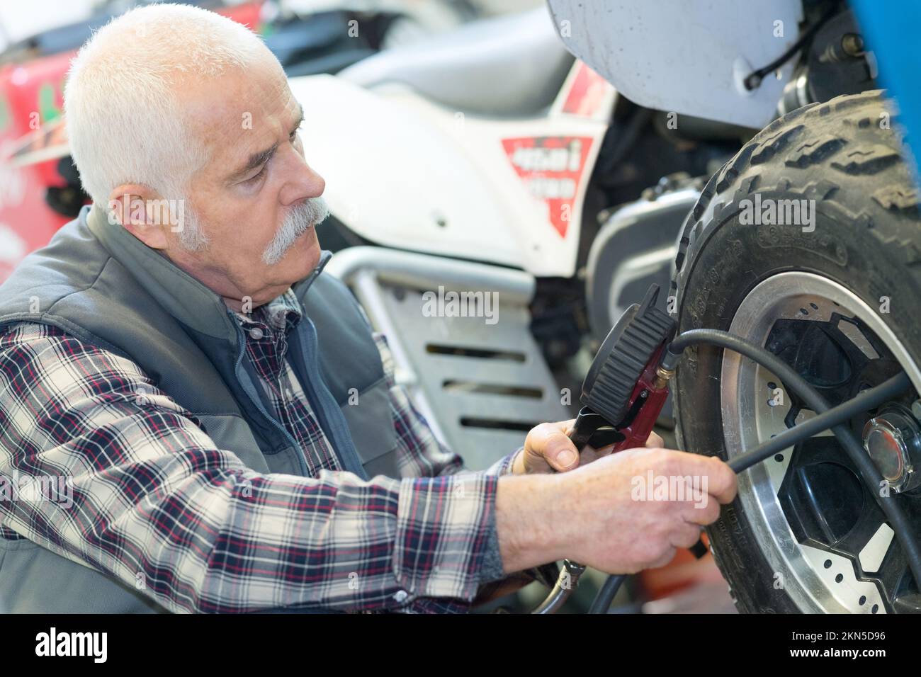 senior biker fixing wheel Stock Photo - Alamy