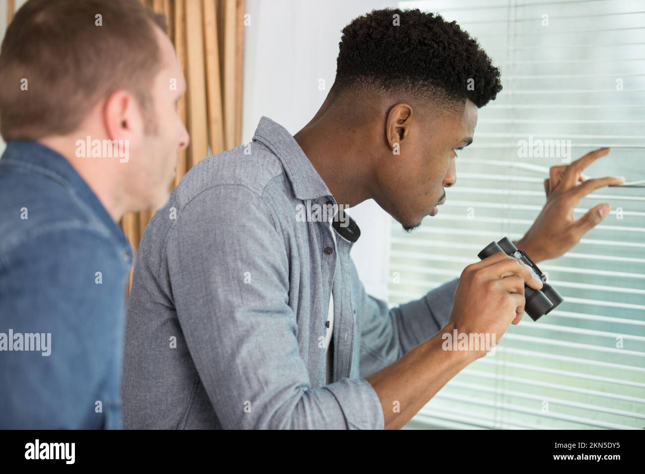 two men are looking at the window Stock Photo - Alamy