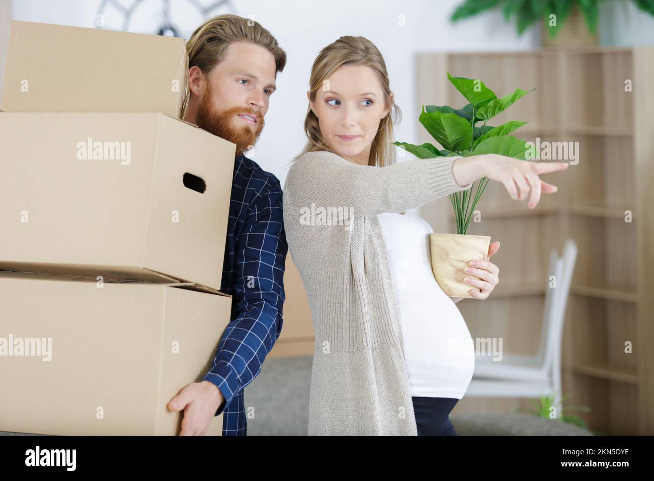 she is pointing where to put the box Stock Photo - Alamy