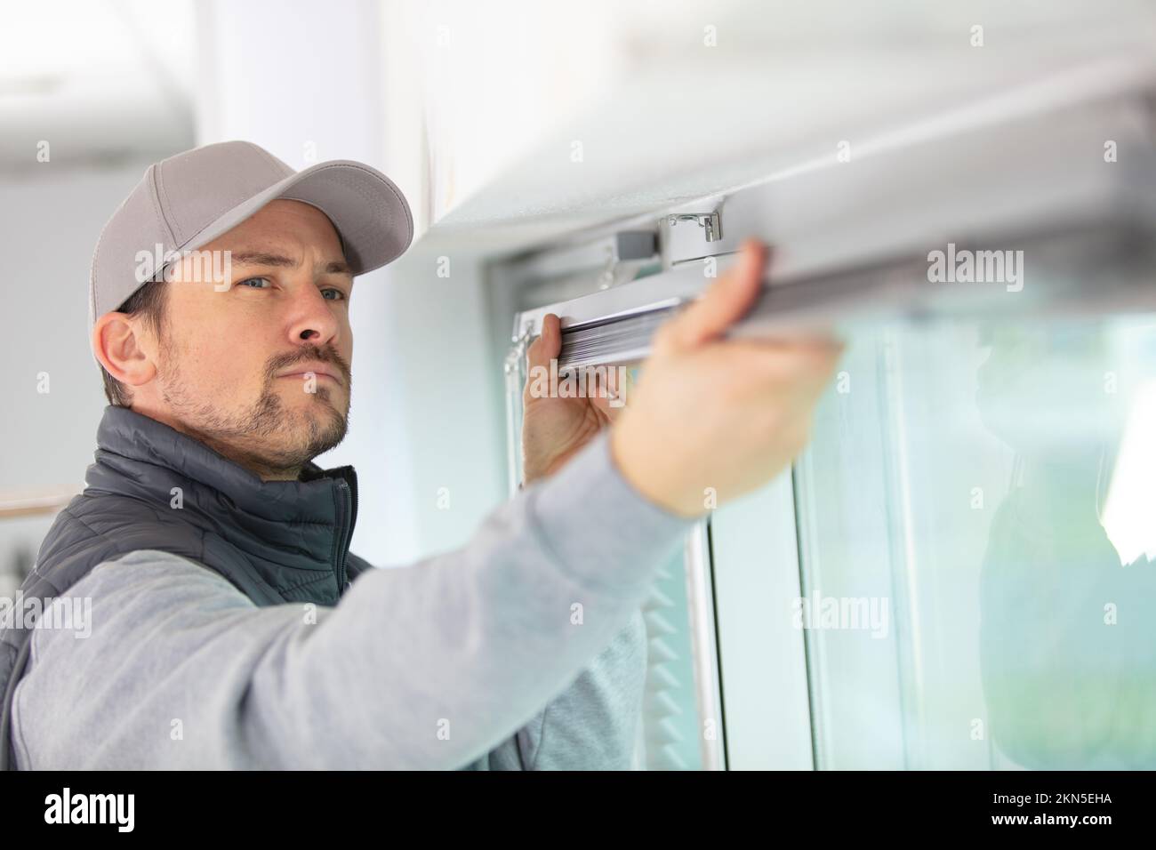 handsome young man installing bay window Stock Photo - Alamy