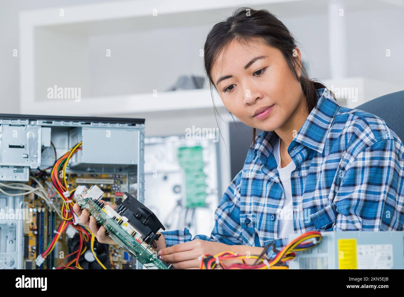 female computer engineer repairing computer motherboard Stock Photo - Alamy