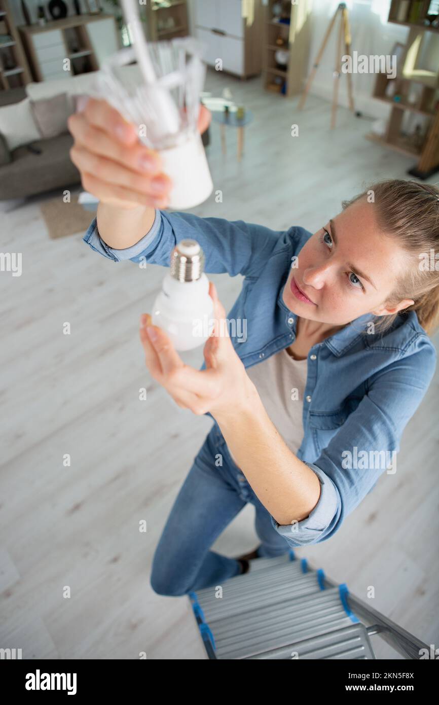 a woman is changing light bulb Stock Photo - Alamy