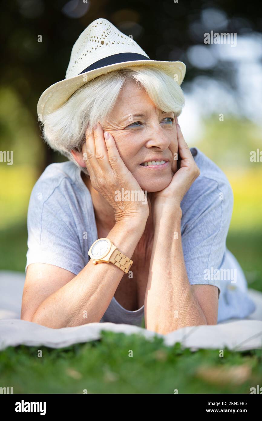 senior woman relaxing in garden by tree Stock Photo - Alamy
