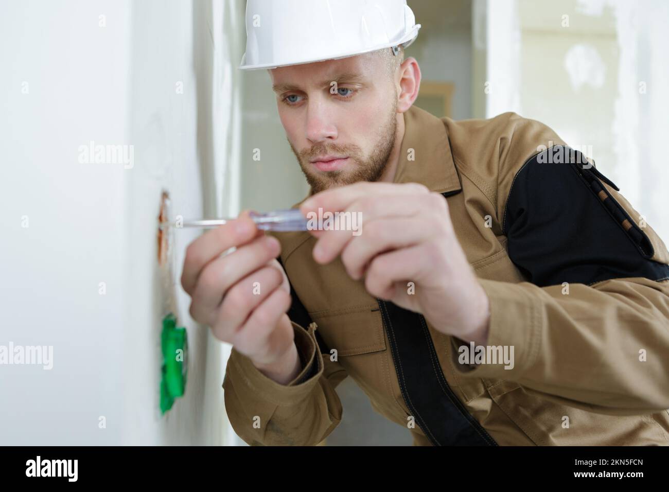 builder with screwdriver fixing socket Stock Photo - Alamy