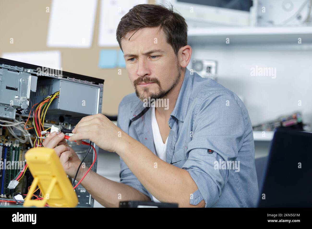 man checking computer with a multimeter Stock Photo - Alamy