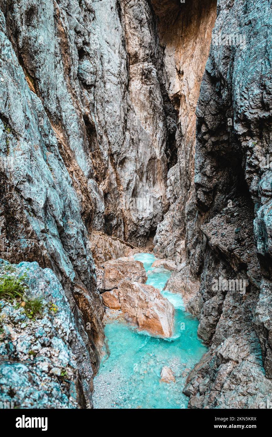 A clear blue river surrounded by big rocks Stock Photo - Alamy