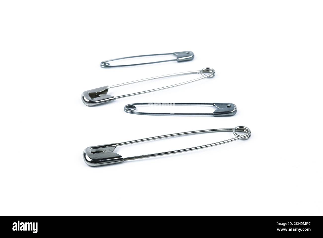 Safety pins standing one after another isolated on white background ...