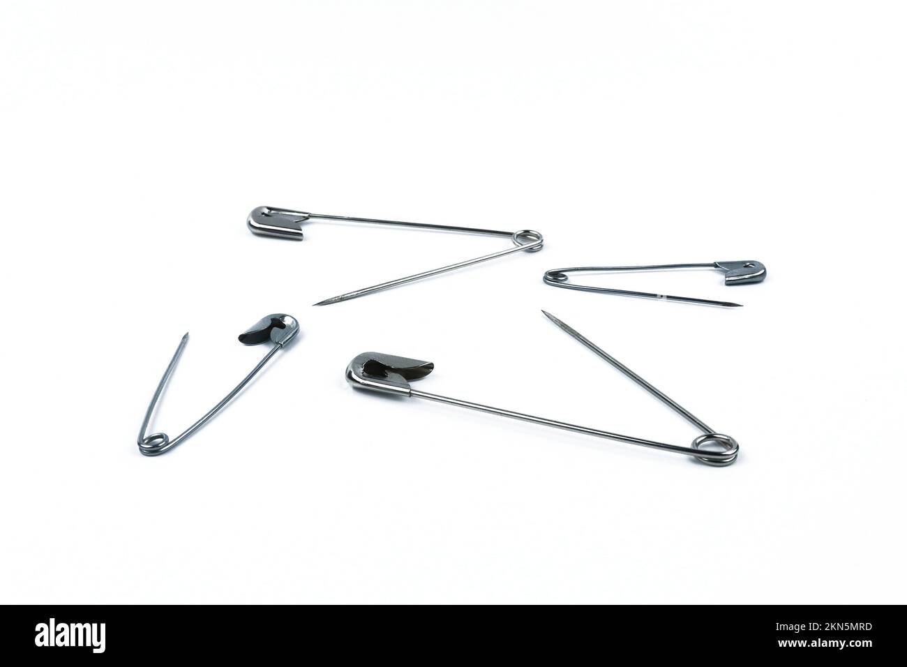 Open and scattered standing safety pins isolated on white background Stock Photo - Alamy