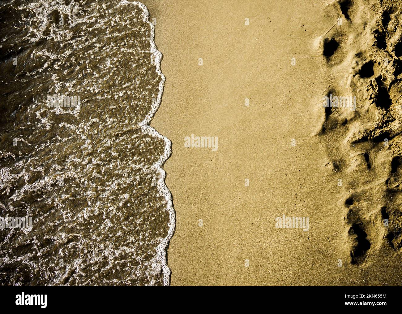 A top view of a beautiful sandy beach with water washing up it Stock ...