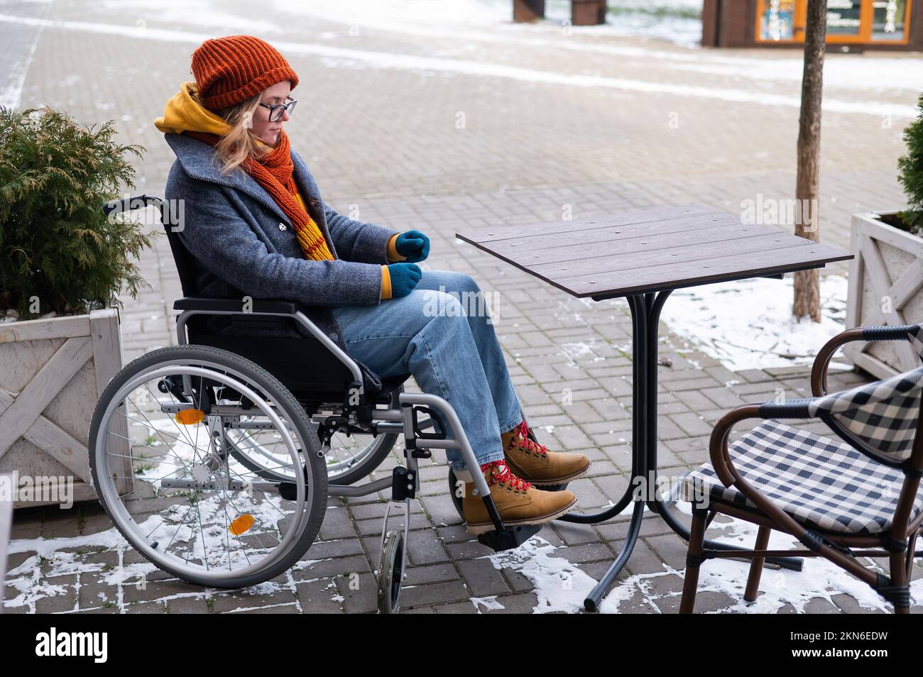 Caucasian woman in wheelchair sitting at outdoor cafe table Stock Photo ...