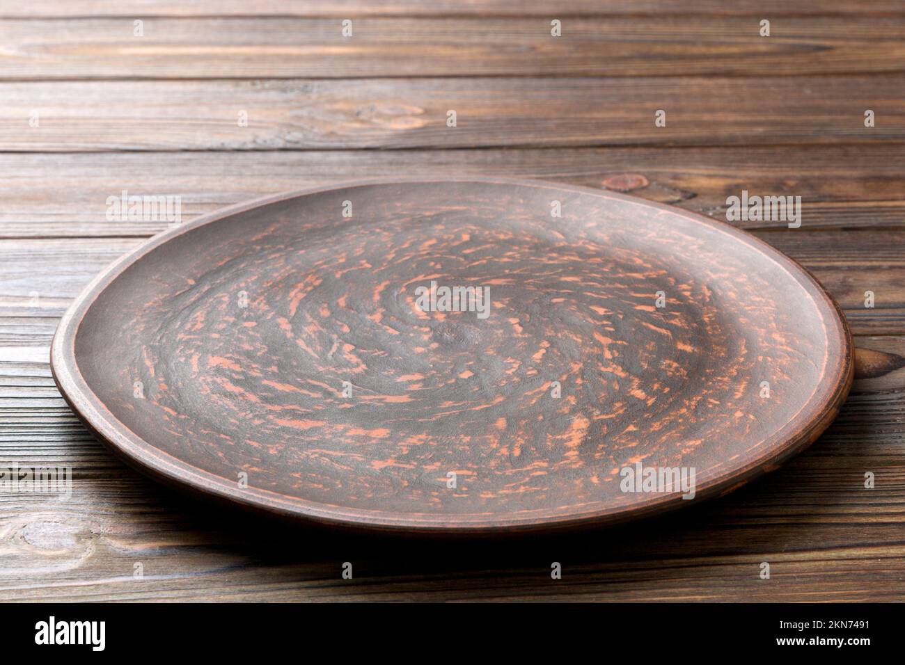 Perspective view of empty black plate on wooden background. Empty space ...