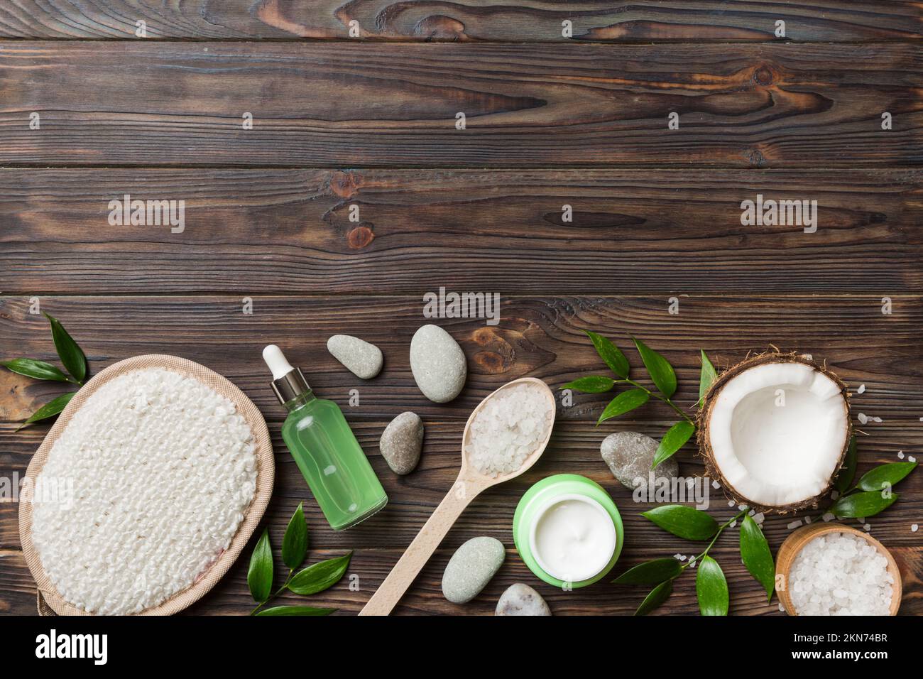 Coconut with jars of coconut oil and cosmetic cream on colored ...