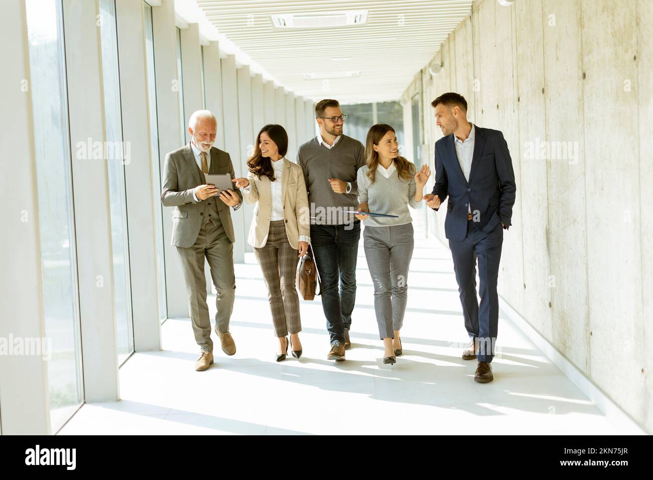 Group of corporate business professionals walking through office ...