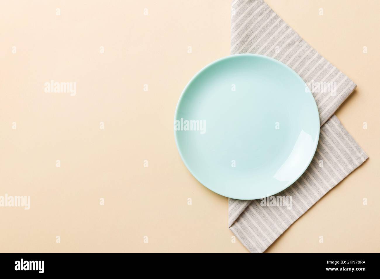 Top view on colored background empty round Blue plate on tablecloth for ...