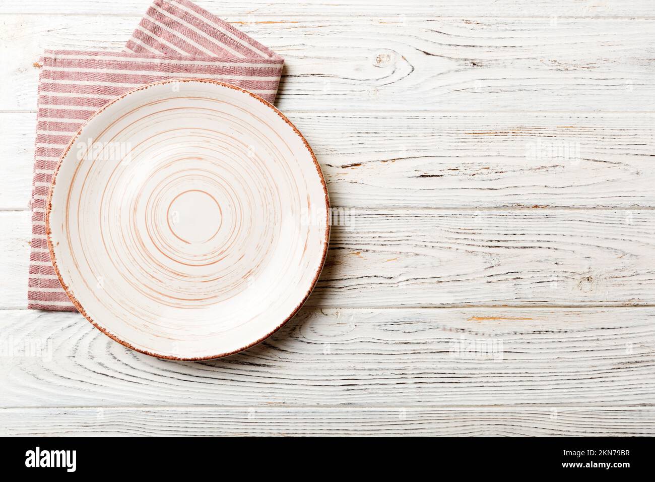 Top view on colored background empty round white plate on tablecloth ...