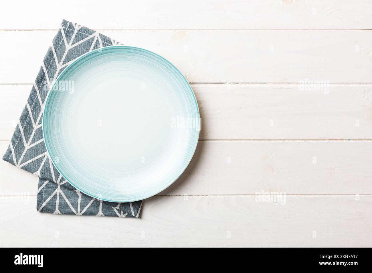 Top view on colored background empty round Blue plate on tablecloth for ...