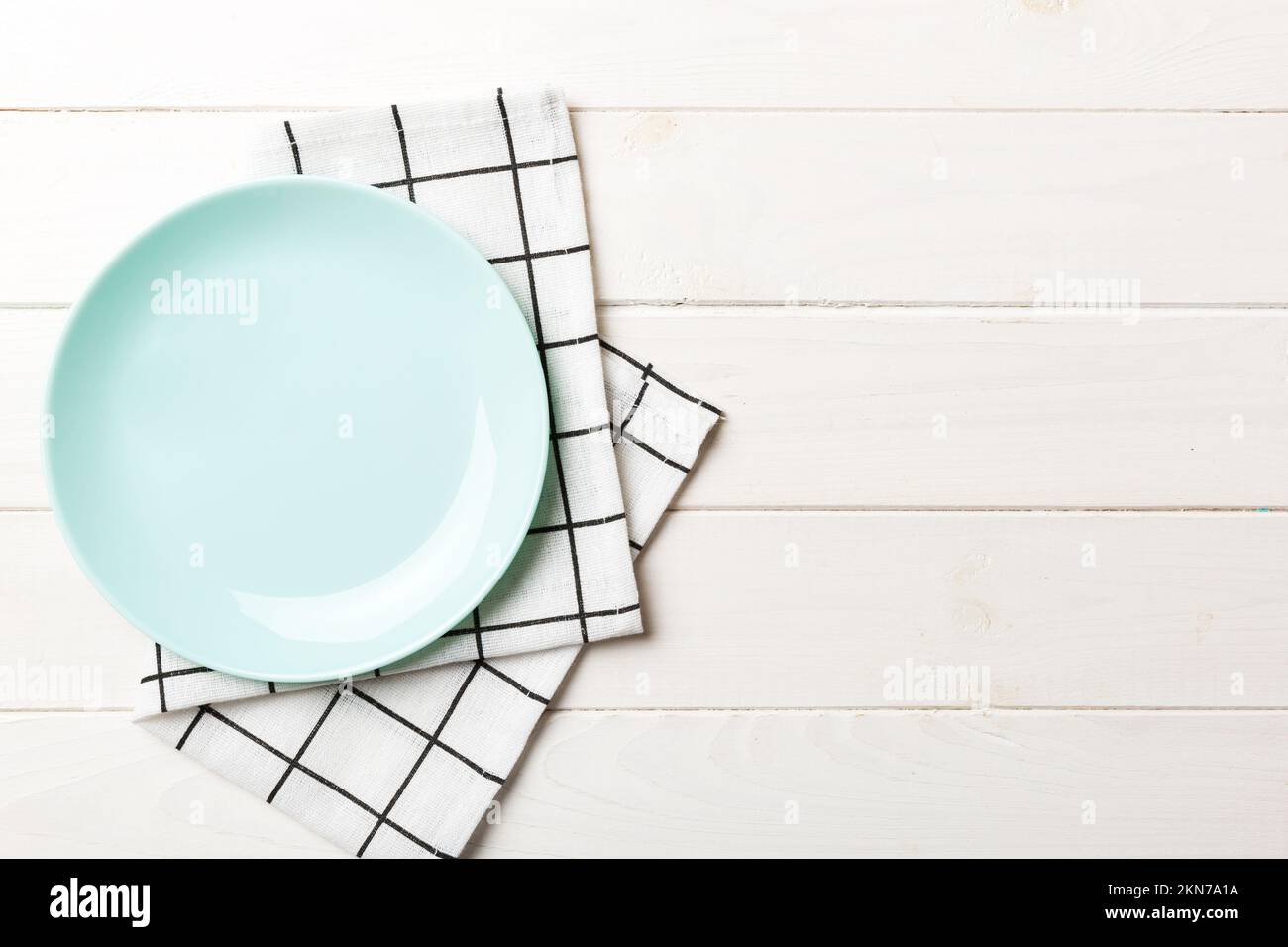 Top view on colored background empty round Blue plate on tablecloth for ...