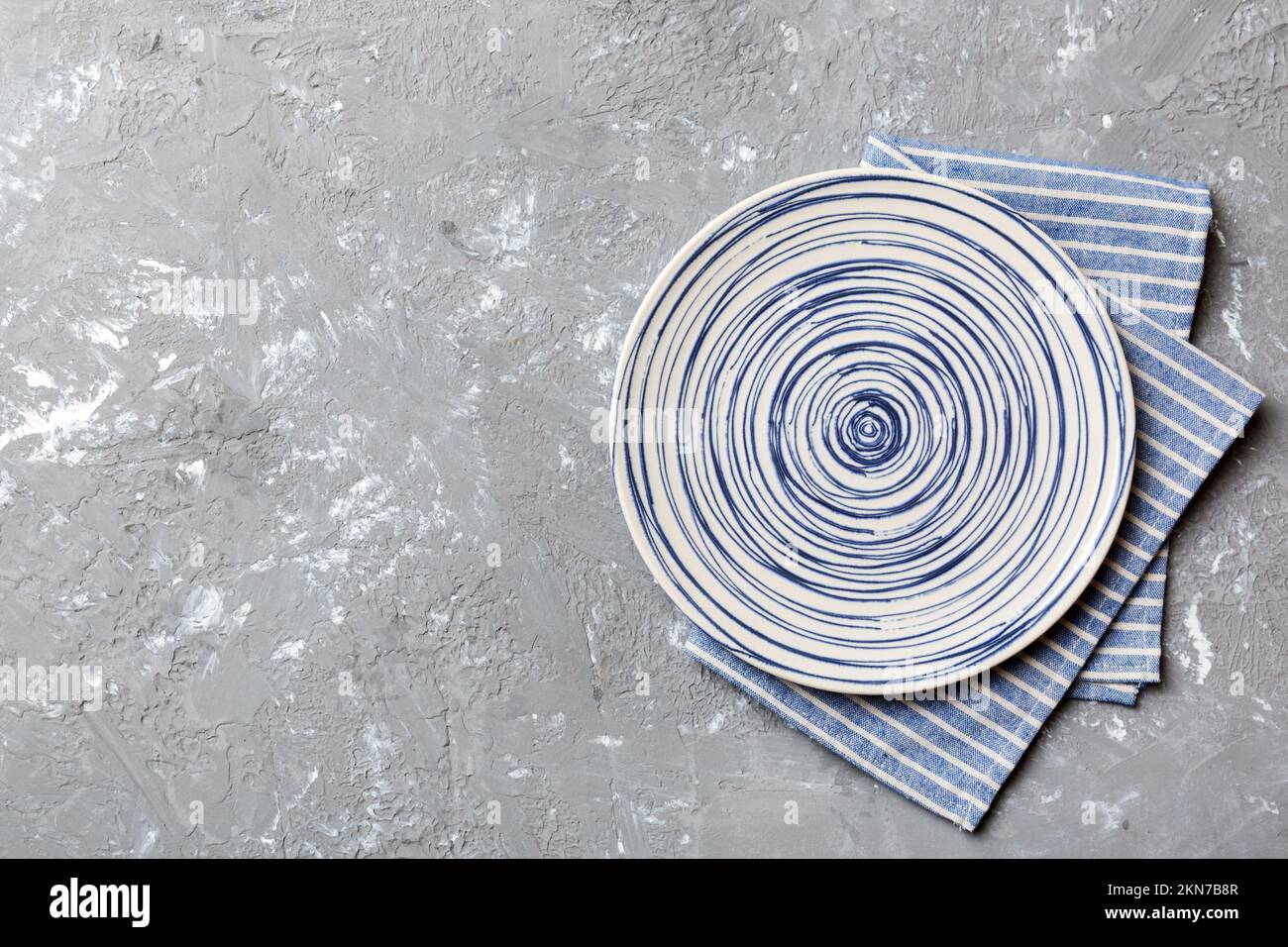 Top view on colored background empty round Blue plate on tablecloth for ...