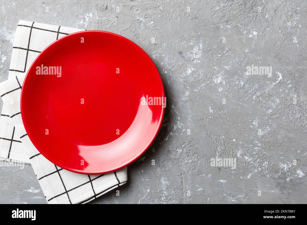 Top view on colored background empty round red plate on tablecloth for ...