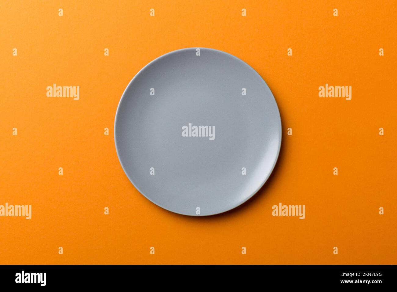Top view of isolated of colored background empty round gray plate for ...