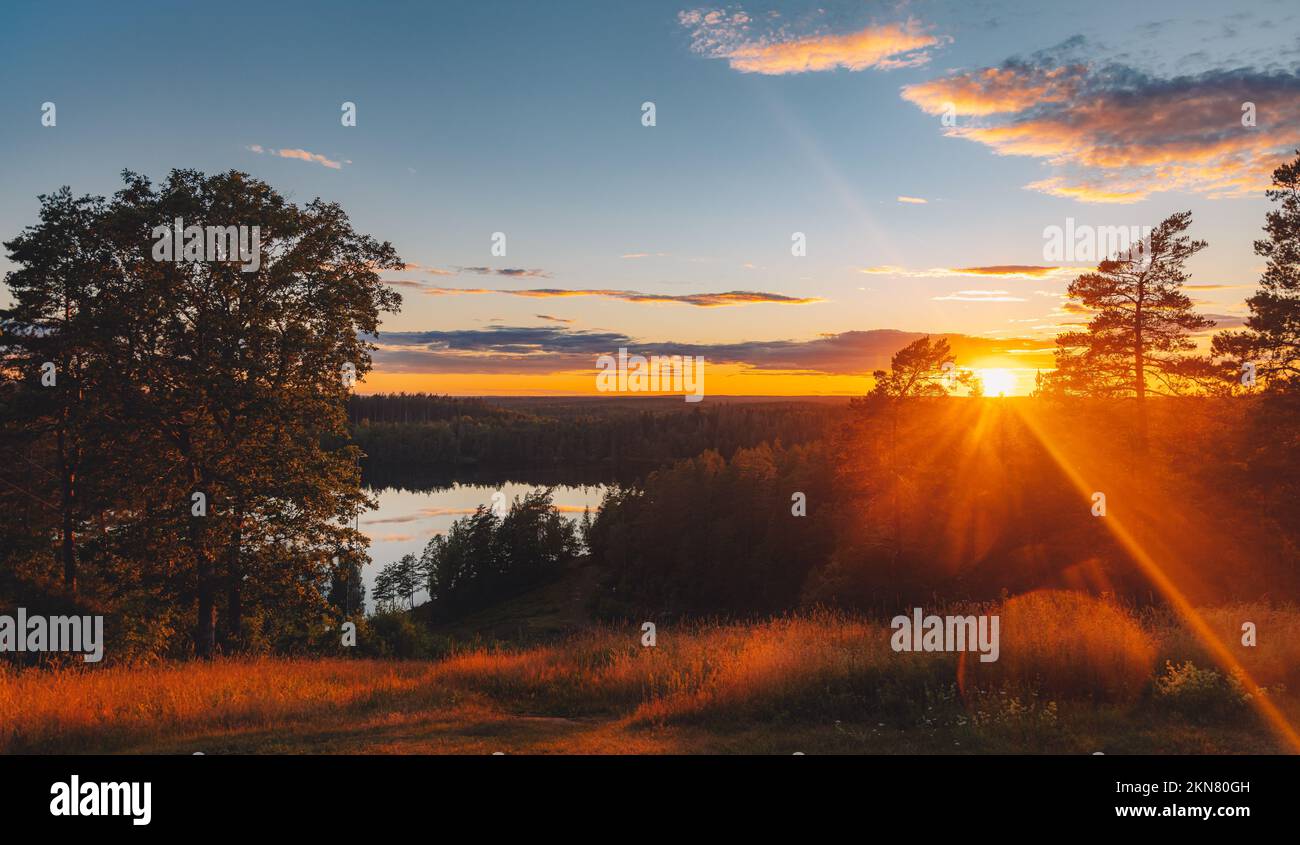 A beautiful view of a calm lake surrounded by trees at dusk in Sweden ...