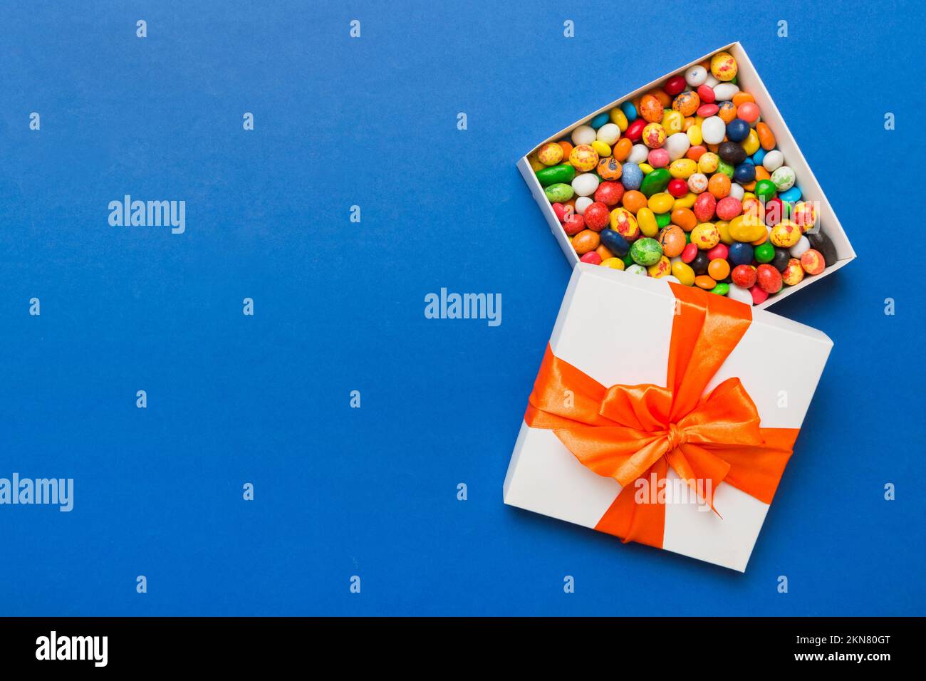 Set of different sweet candy in a paper box with a satin ribbon on a ...