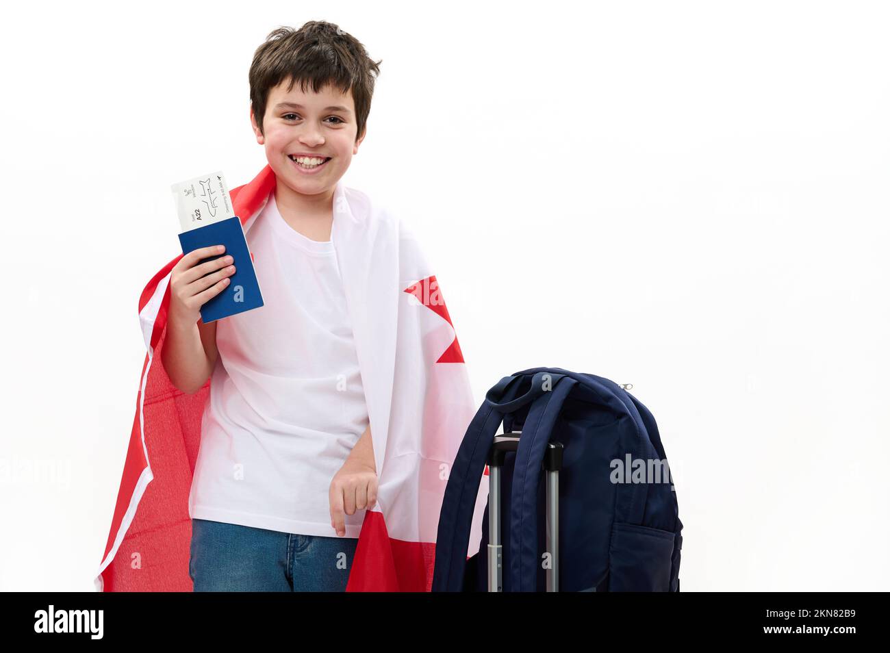 Multiethnic smart smiling teenage school boy posing with Canadian flag ...