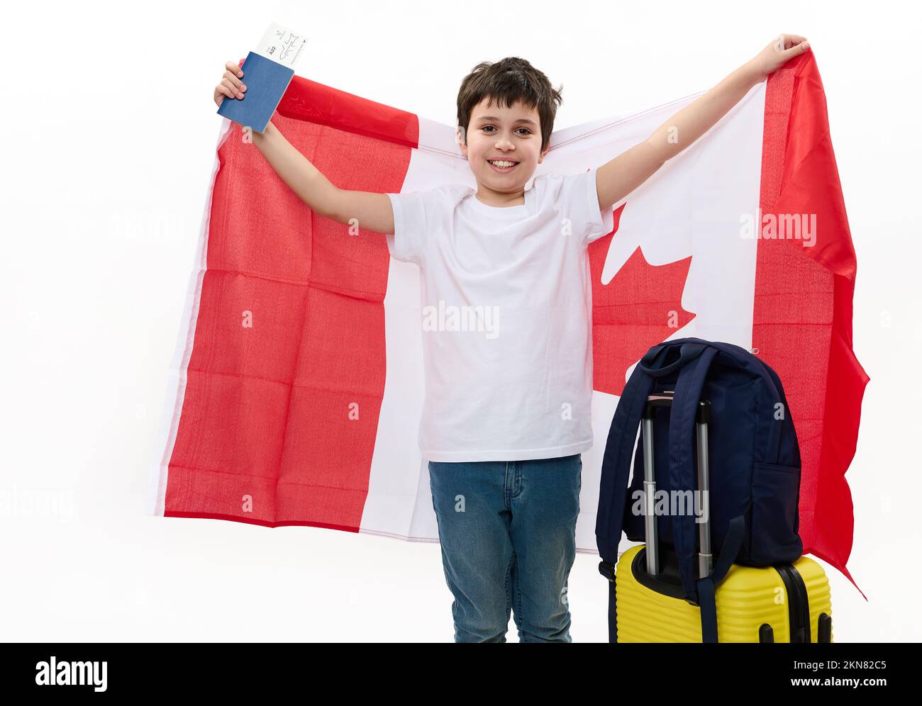 Smart Caucasian teenage boy with backpack, suitcase and Canadian flag ...