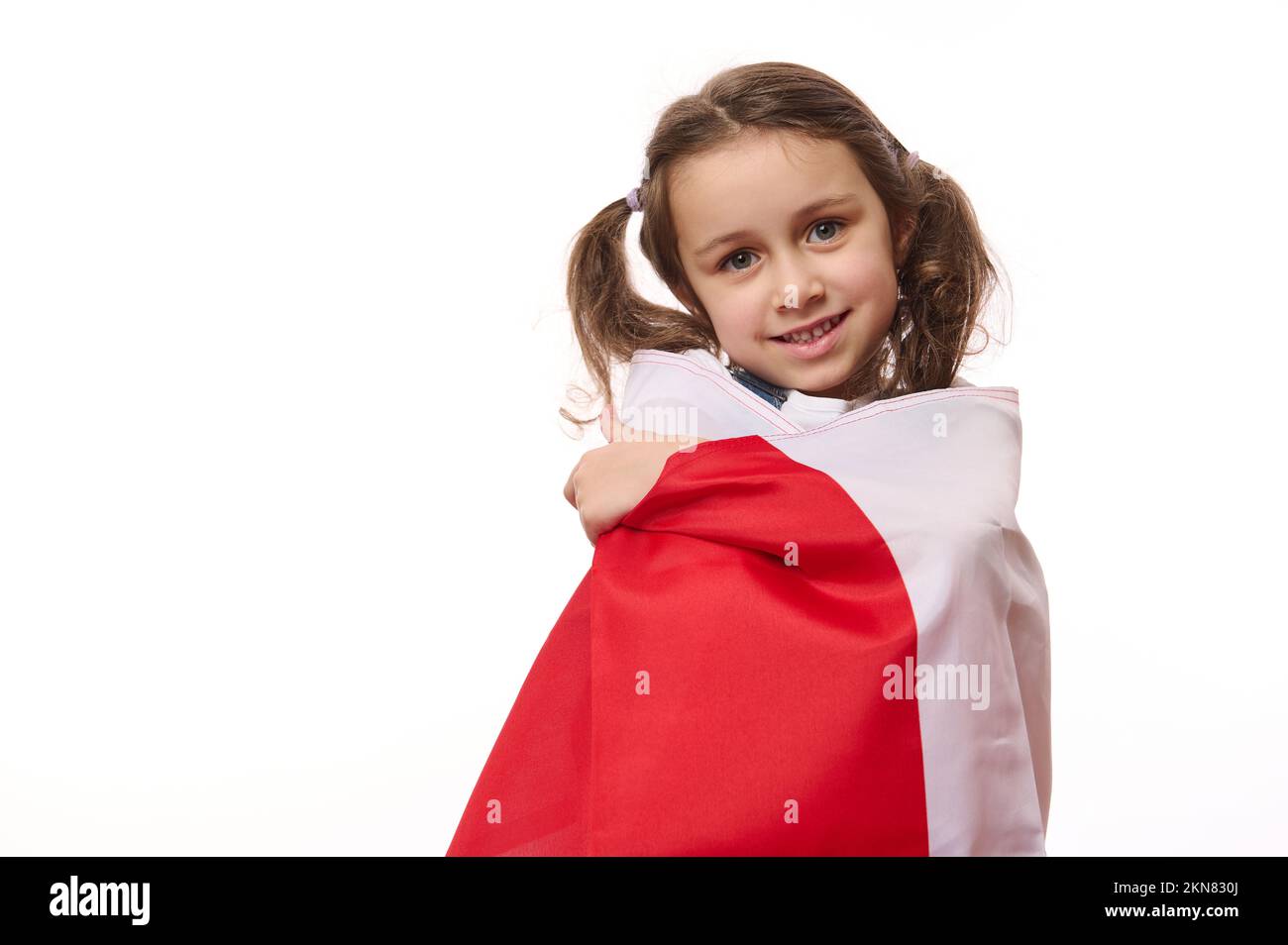 Beautiful child girl proudly wrapping in flag of Poland or Canada ...